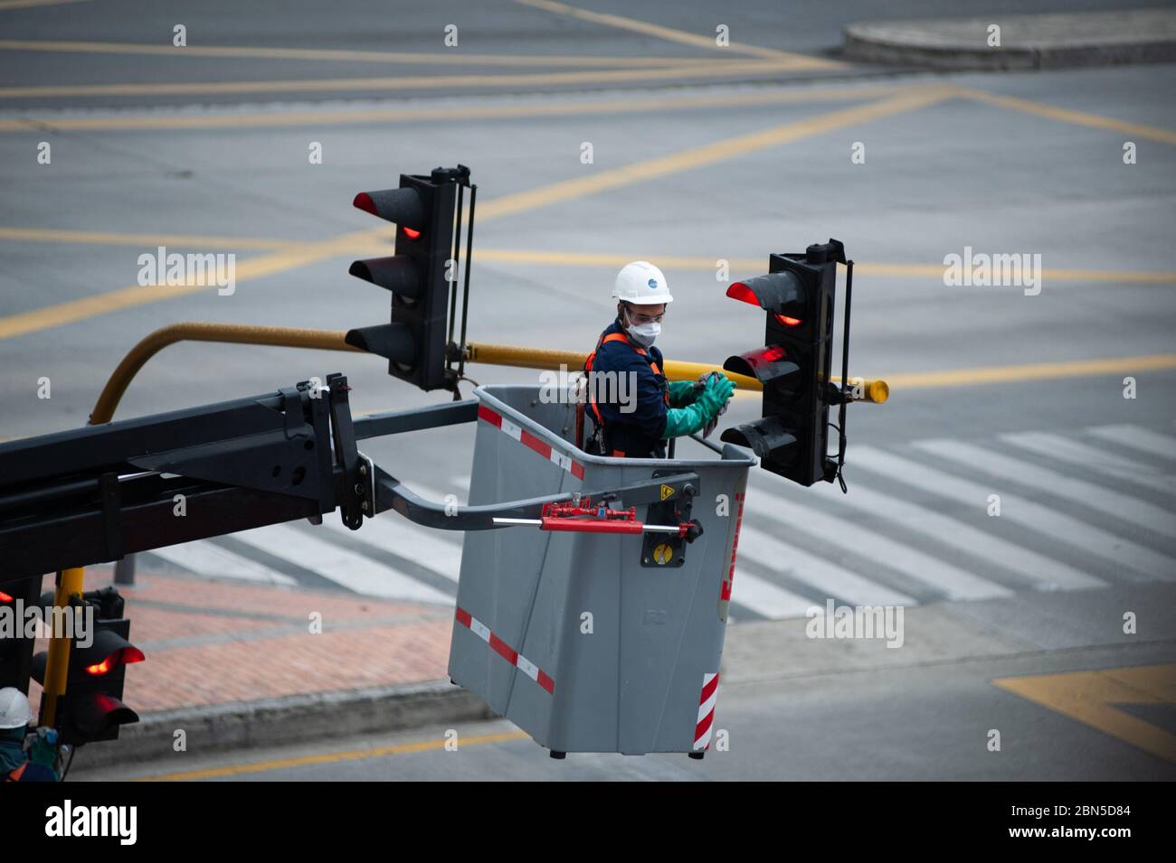 Cleaning staff disinfects traffic lights to prevent possible infections ...