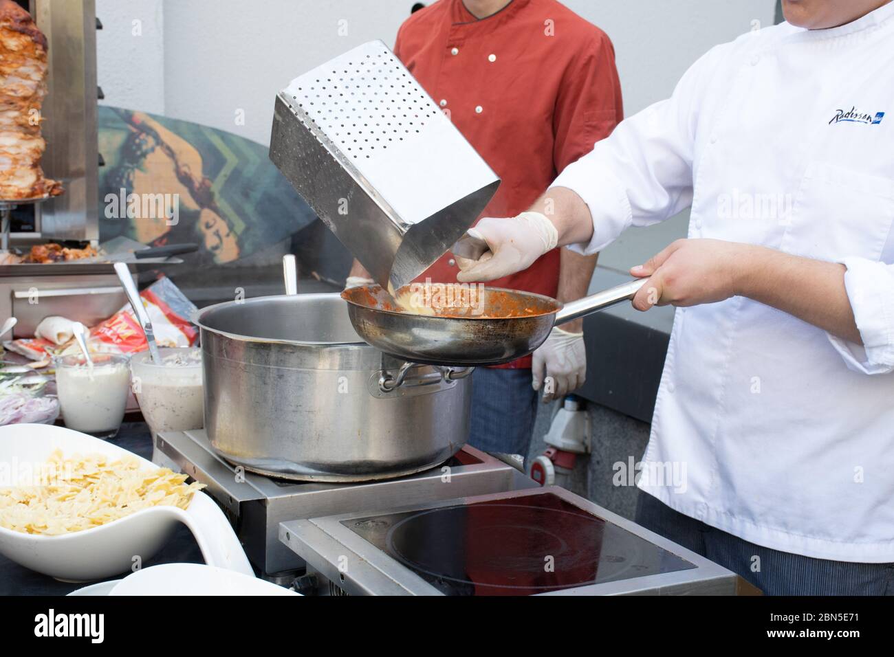 Chef preparing pasta boiling pasta and cooking. Food catering live ...