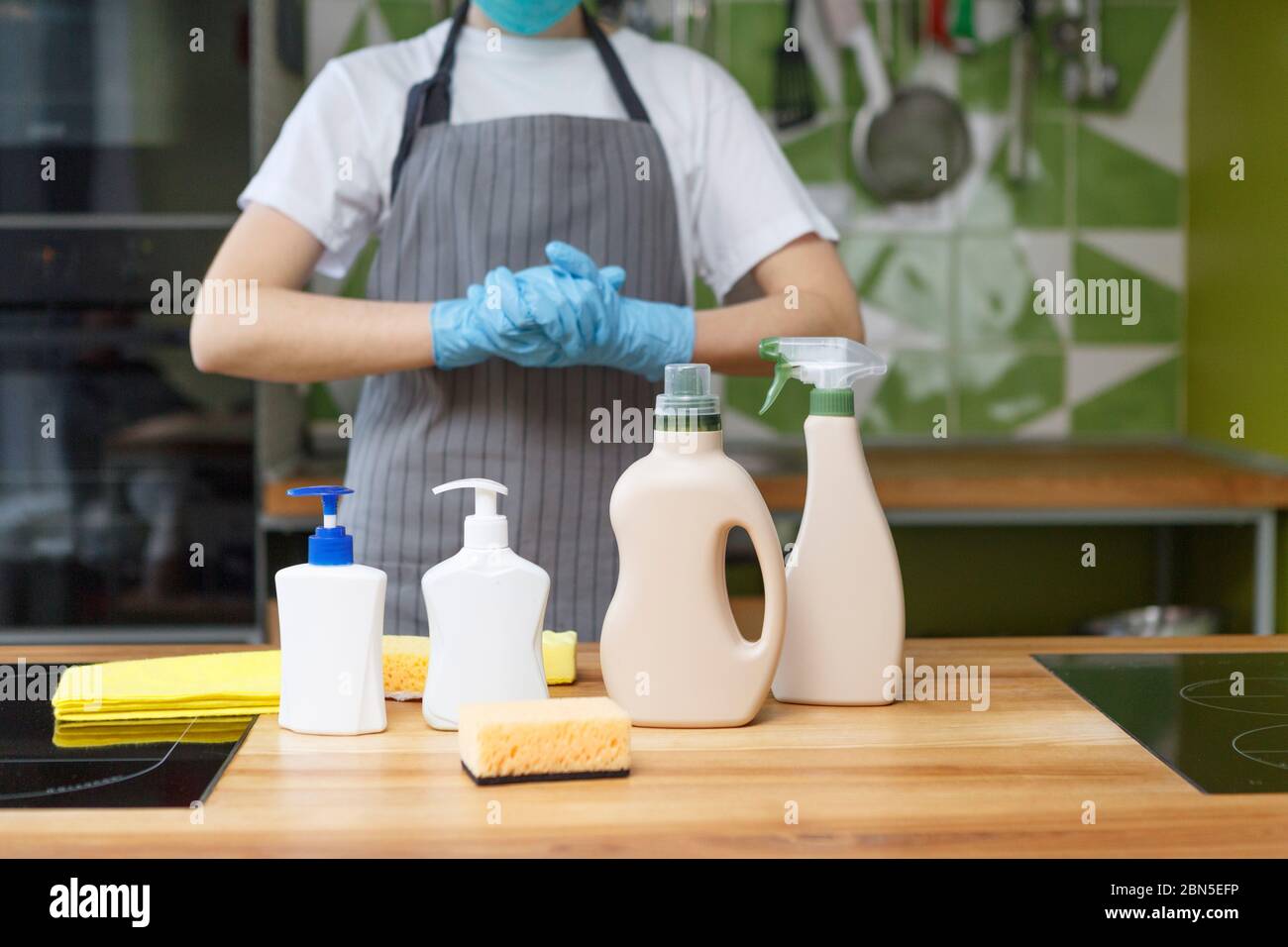 Woman showing eco disinfection detergents for cleaning kitchen surfaces ...