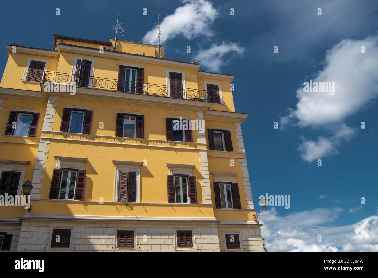 Multi story Yellow Building on a bright semi cloudy day Stock Photo - Alamy