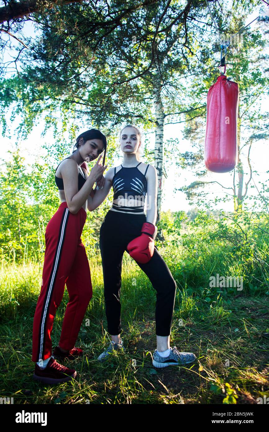 two diverse nations girls fighting boxing outside in green park, sport ...