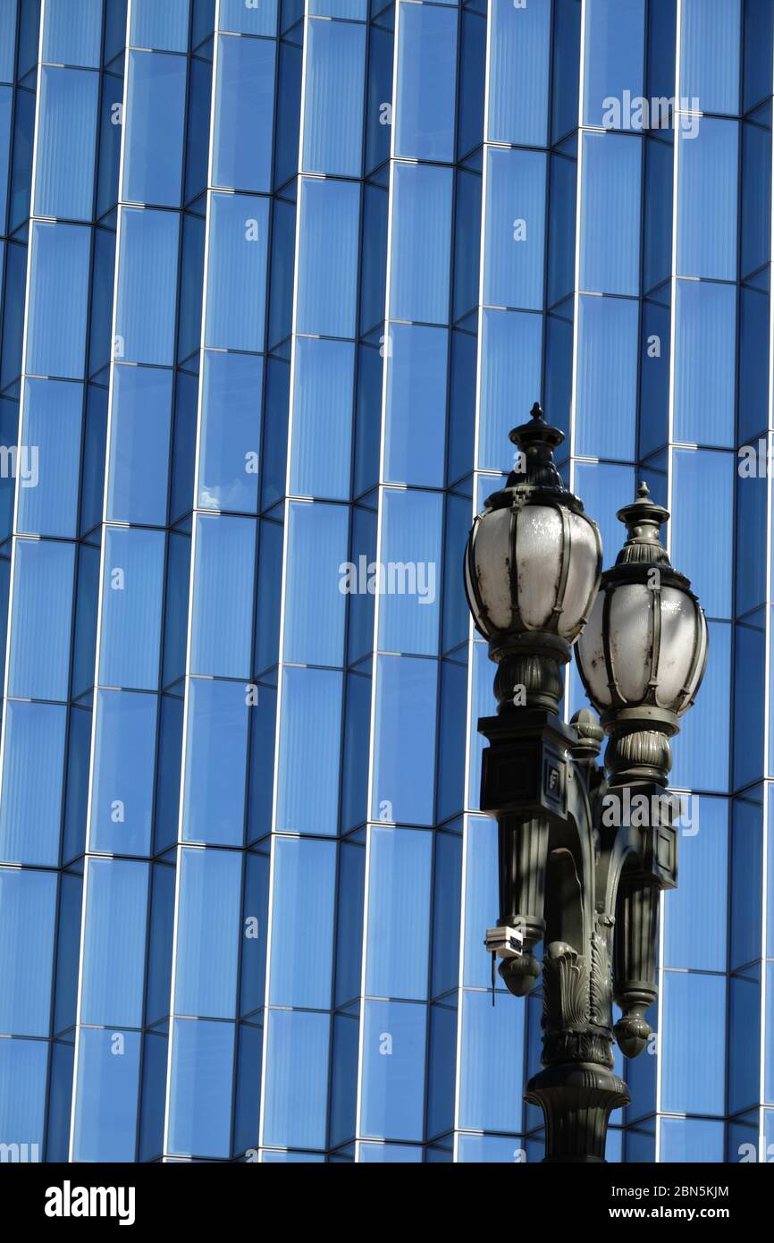 Traditional historic street light set against a modern glass skyscraper ...