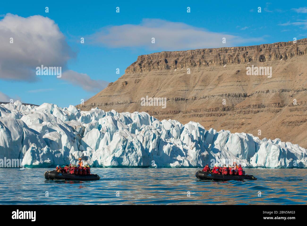 Rubber dinghies with tourists in front of glaciers, Croker Bay, Nunavut ...