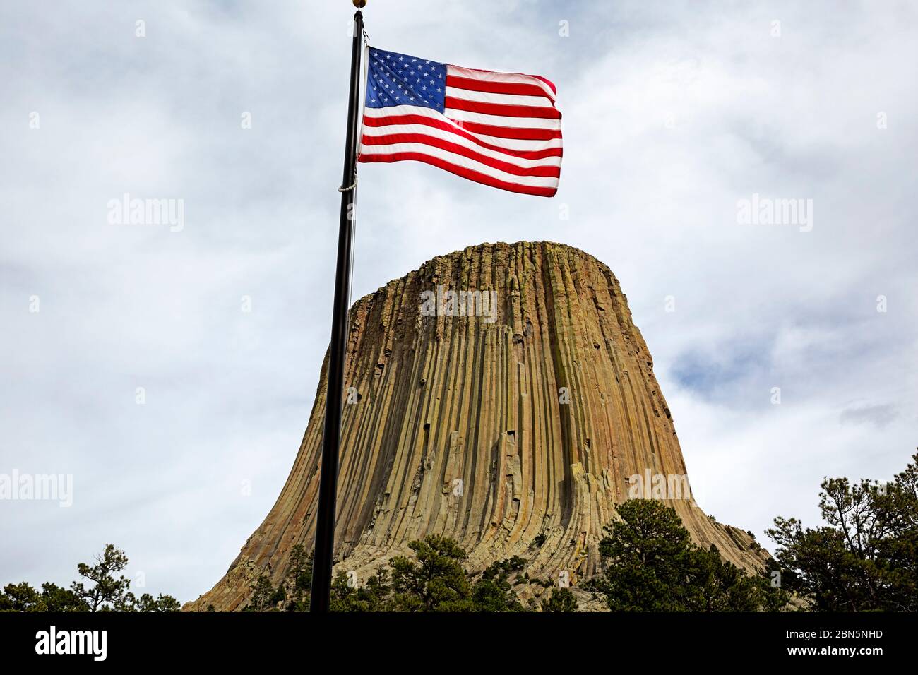 WY04239-00...WYOMING - The United States flag and Devil's Tower at the ...