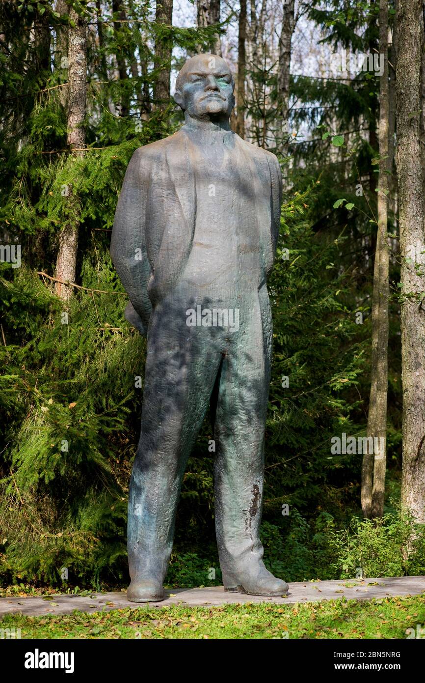A large, bronze statue, aged with green patina of a standing Lenin. At ...