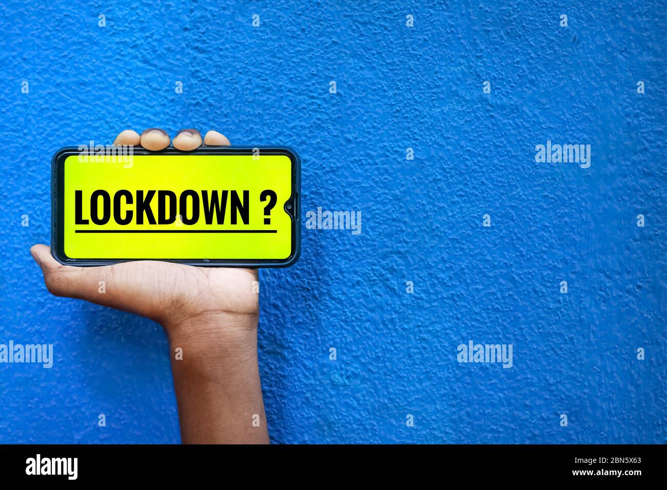 Lock down wording for Covid-19 on smart phone screen isolated on blue ...