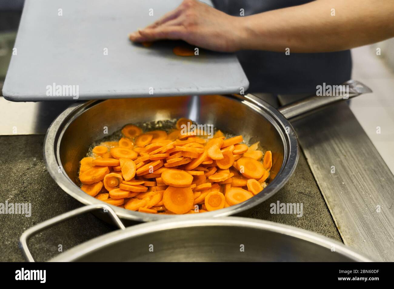 The preparation of food in the cafeteria fast food. Roasting carrots ...