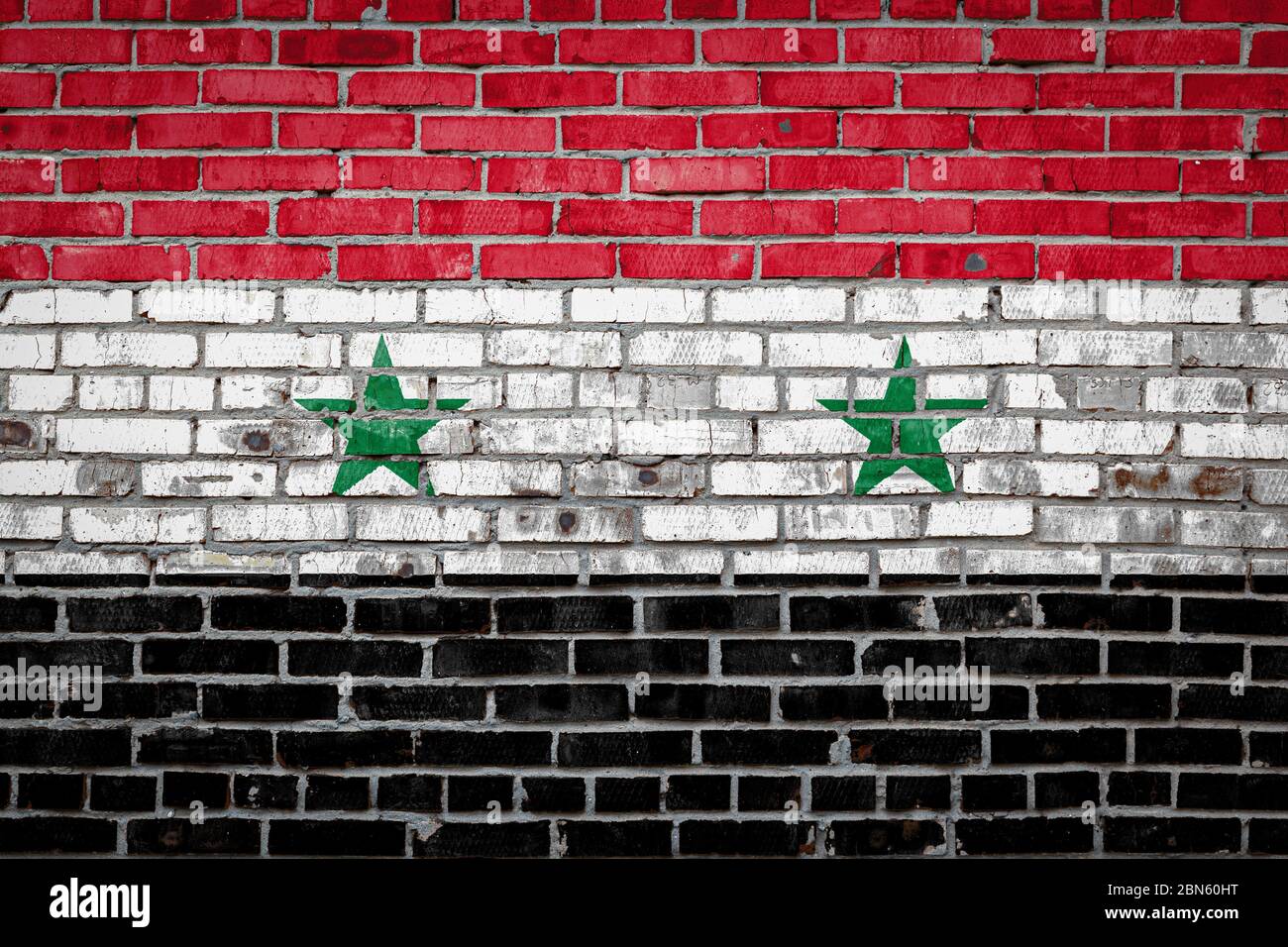 National flag of Syria depicting in paint colors on an old brick wall ...