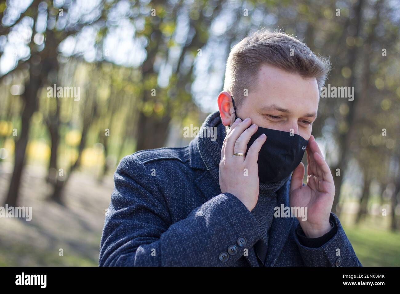 Man adjusts a mask while walking Stock Photo - Alamy