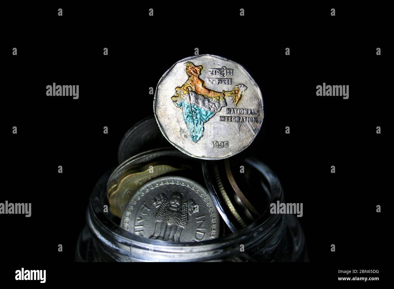 Two rupee coin of India isolated on black background. Map of India as a ...