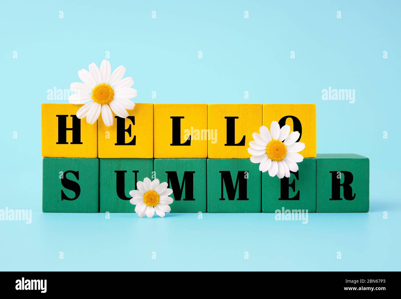 Hello Summer text written on two rows of yellow and green wooden blocks ...