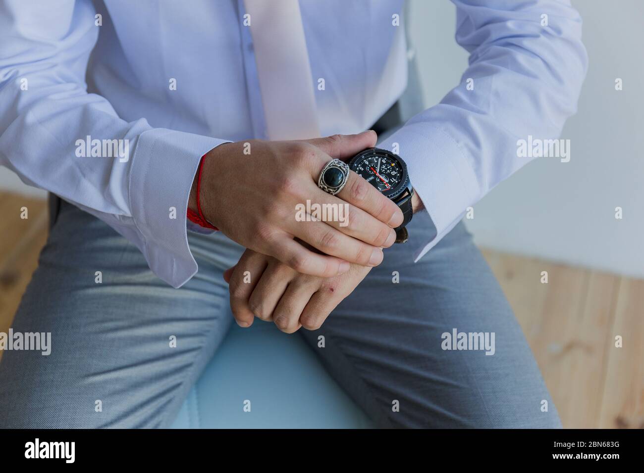 a man in a shirt puts watch on his hand Stock Photo - Alamy