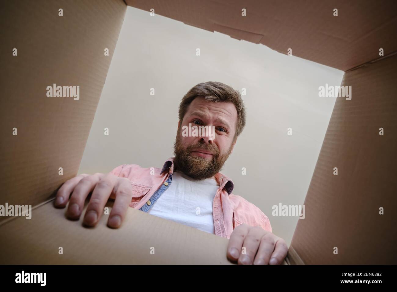 Man looks into an unpacked, delivered box and is upset because he ...