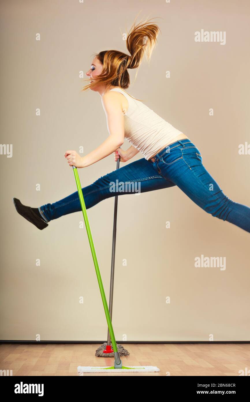 Cleanup housework concept. Funny cleaning lady young woman mopping floor, holding two mops new ...