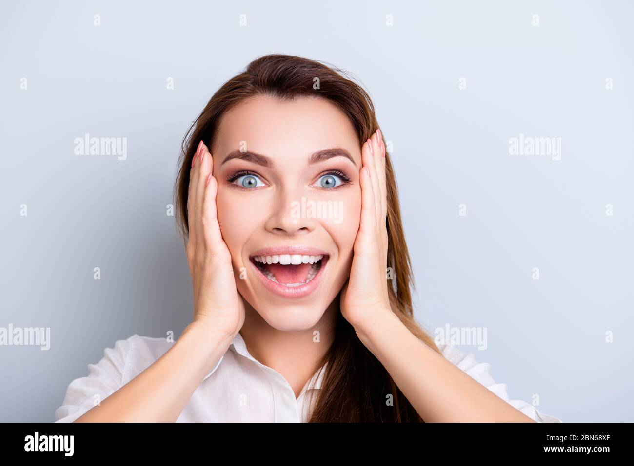 Close up cropped portrait of cute amazed girl in white shirt, holding ...