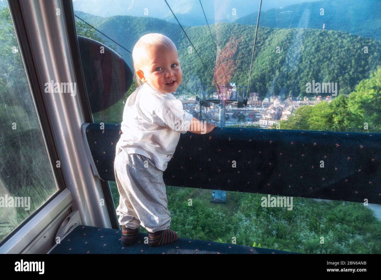 Cute little boy enjoying ride in cable car during summer vacation ...
