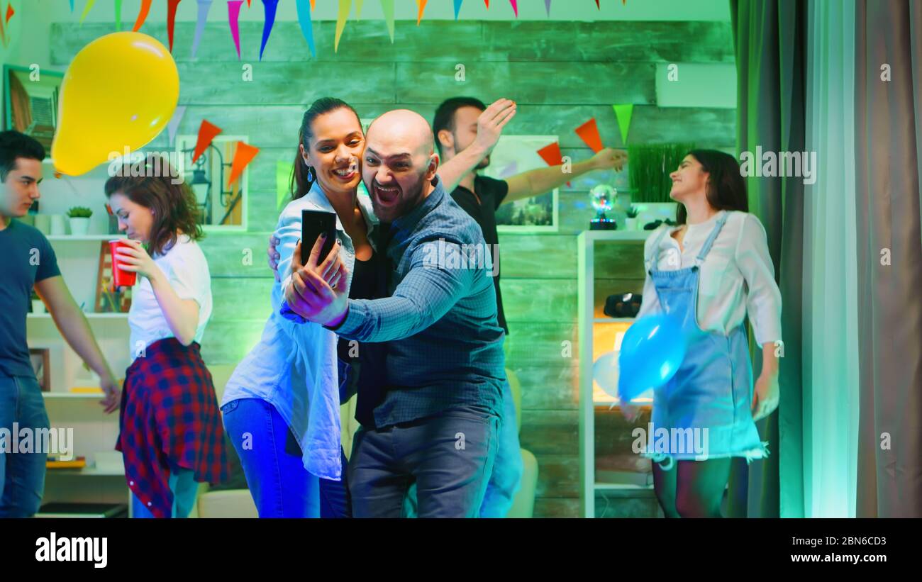 Cheerful bald man taking a selfie with his attractive friend at the ...