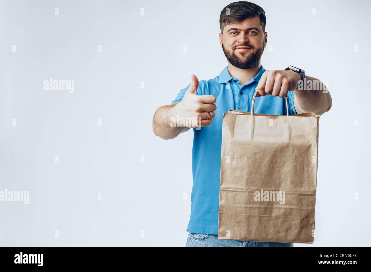 Delivery man with bag order from groceries on grey background Stock ...