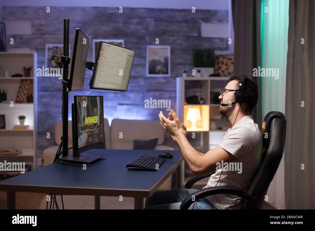 Side view of professional shooter gamer clapping after his victory on ...
