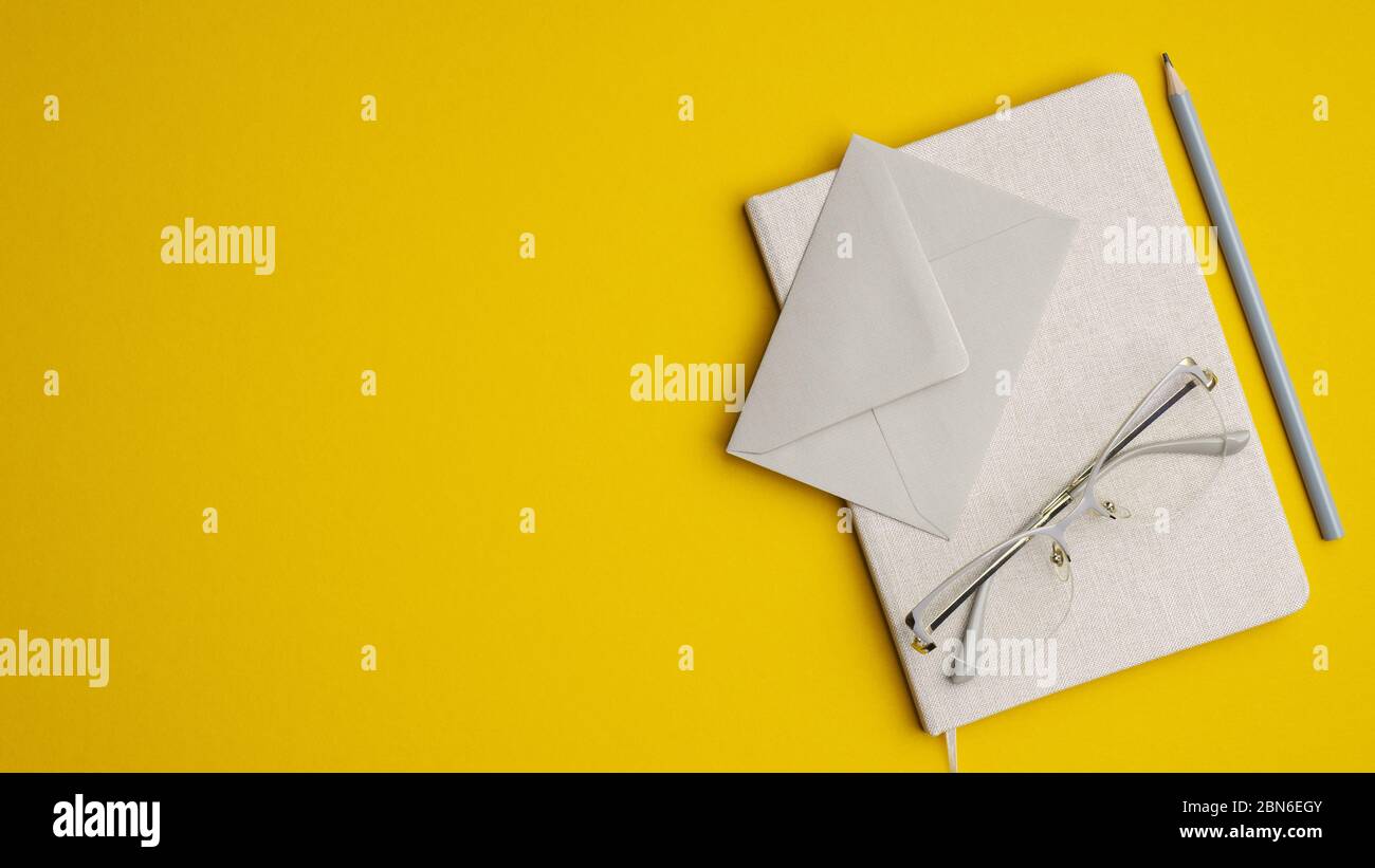 Office desk table with notebook, paper envelope, glasses and pencil on ...