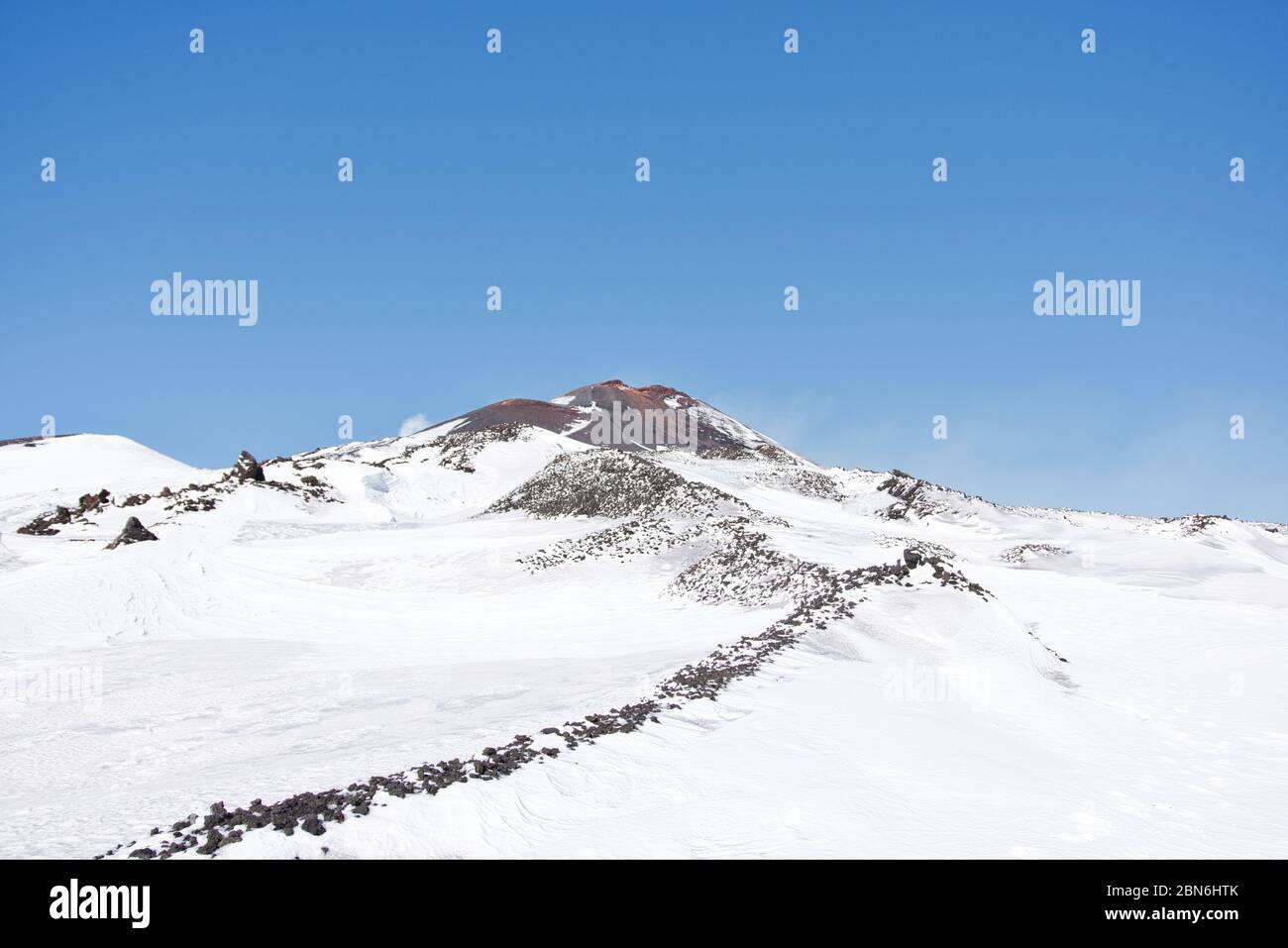 Snowy volcano with smoke in sicily with blue skies Stock Photo - Alamy