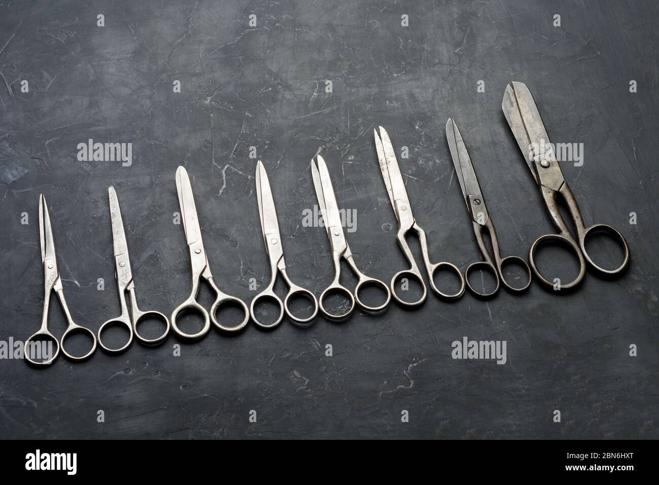 Many different scissors on dark background. Minimal black. Flat lay ...