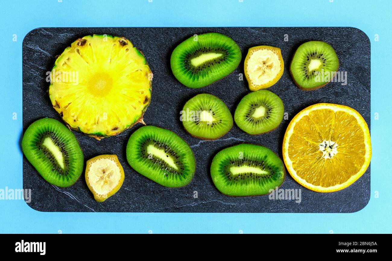 Cut and sliced fruits - pineapple, kiwi, orange, banana. View from ...
