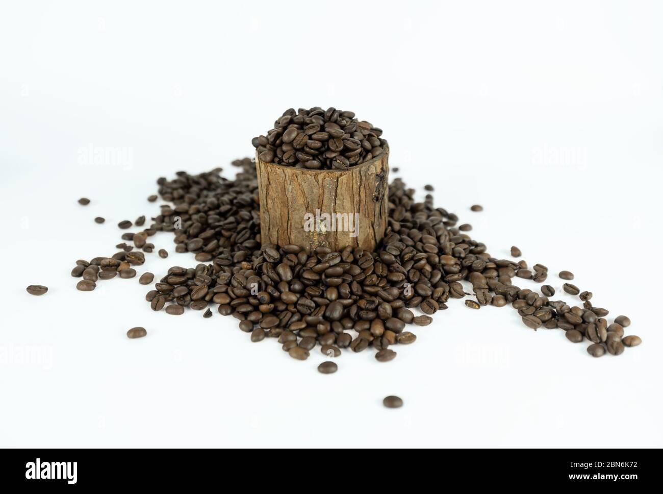 Coffee beans lying on small stump and around Stock Photo - Alamy