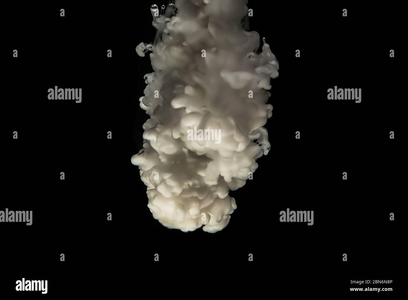 White milk pressure jet motion on dark background, mixing and swirling ...