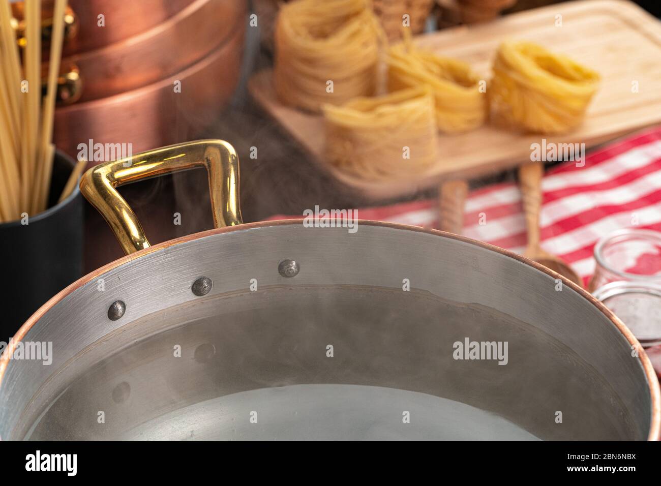 Copper pot with boiling water on a gas stove Stock Photo - Alamy