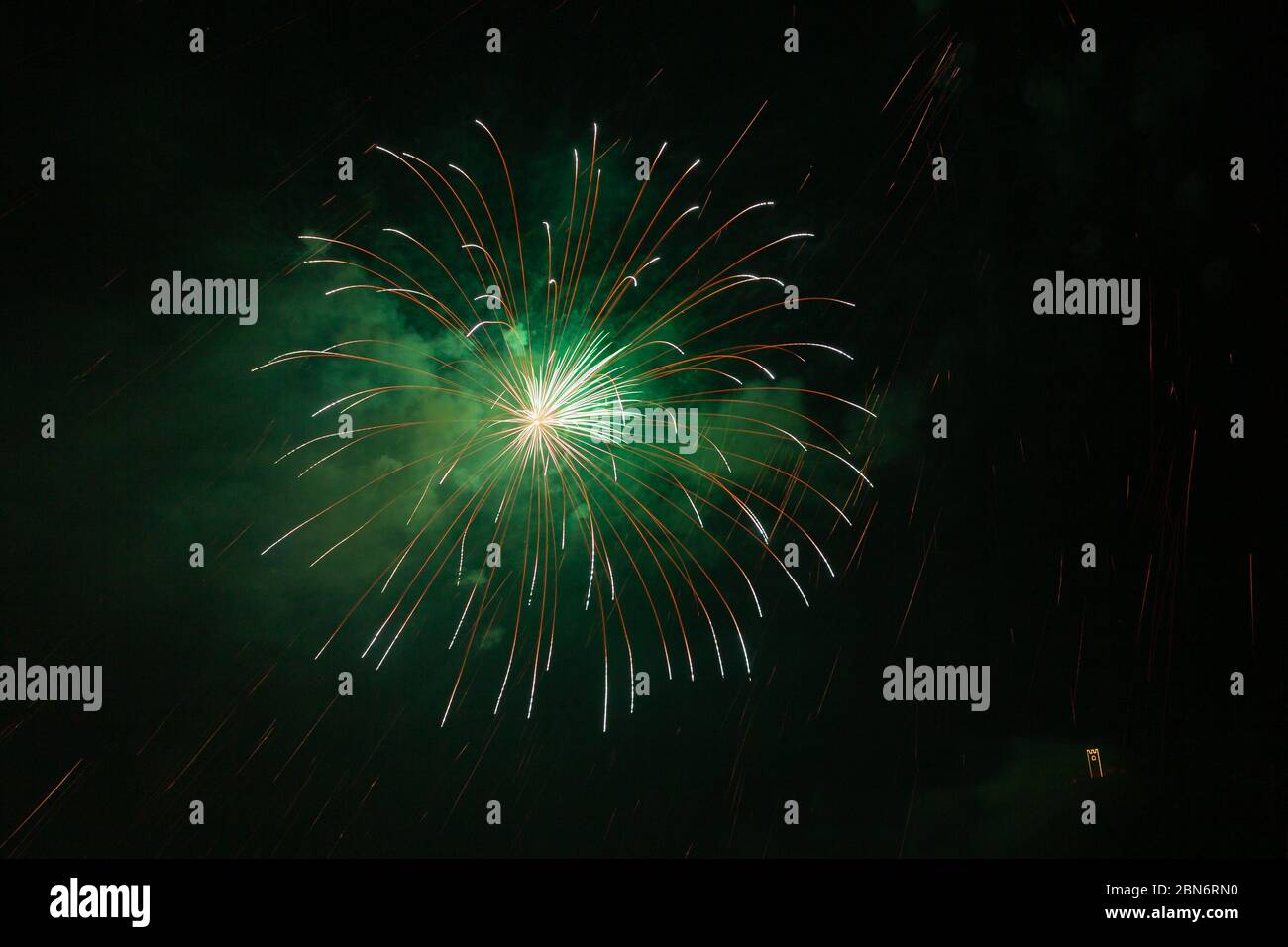 Green, white and orange fireworks over an illuminated church Stock ...