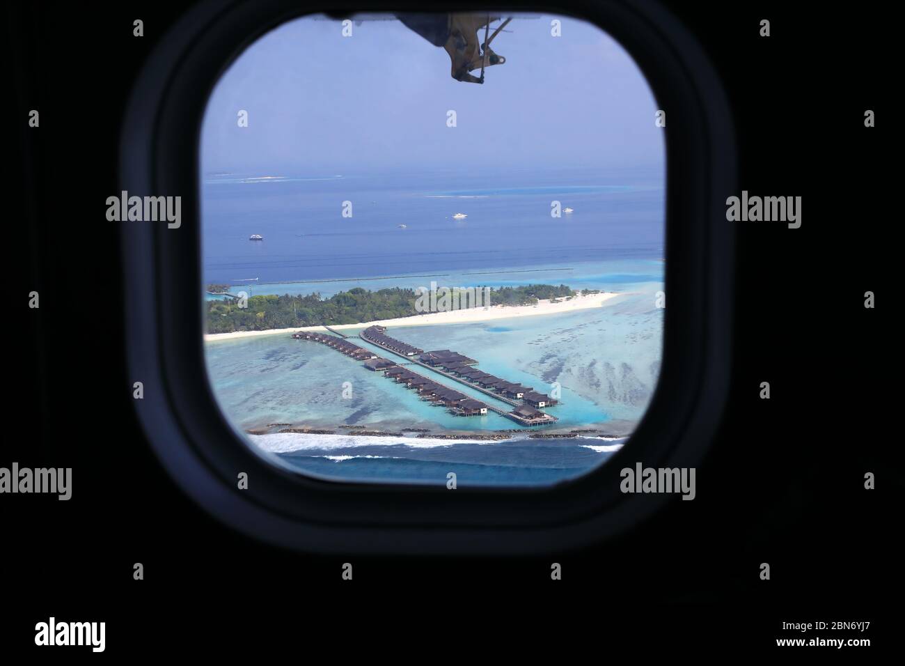 Aerial view through airplane windows on tropical island of the Maldives ...