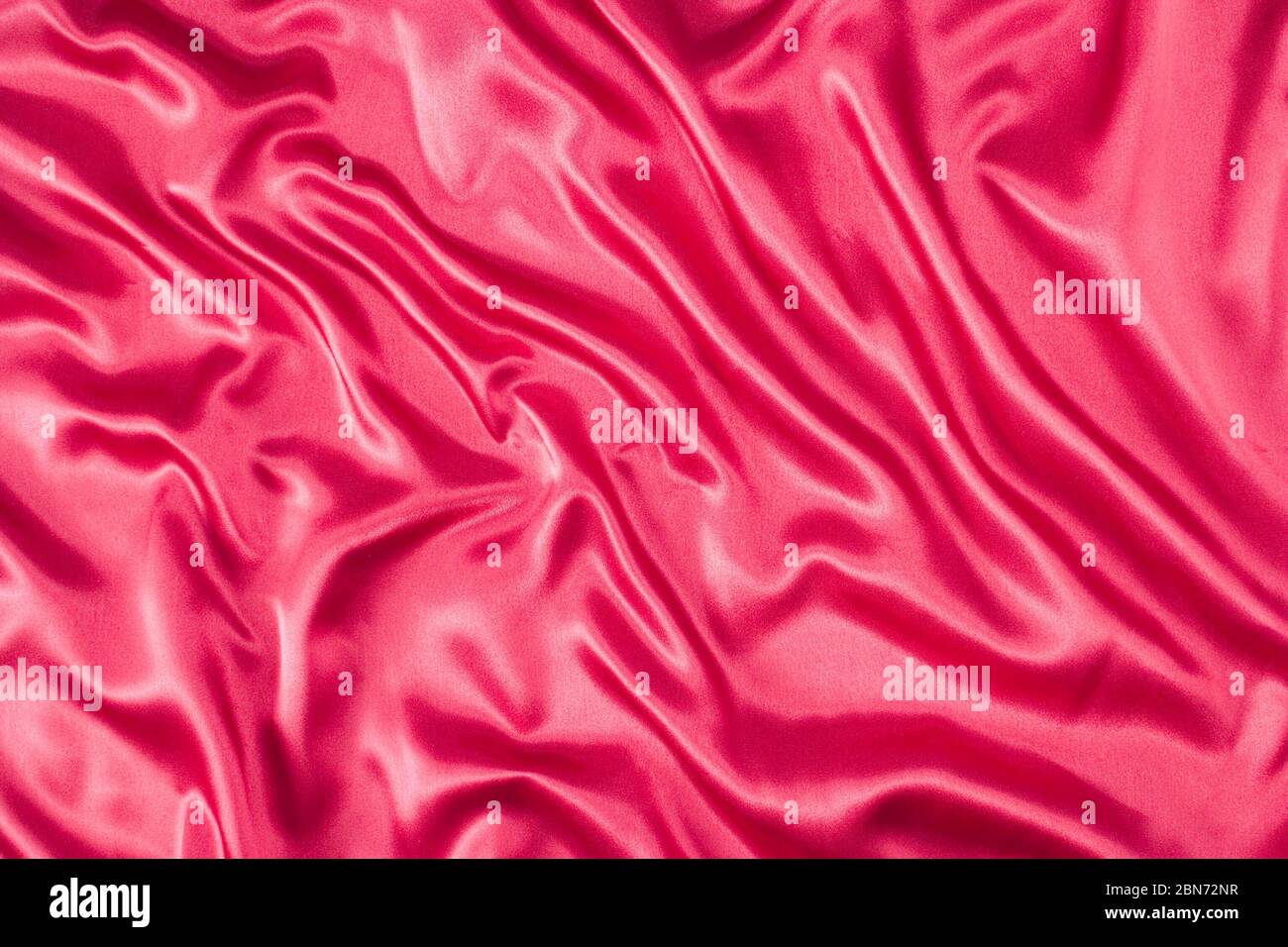Bright pink, cerise silk folded fabric background, luxurious textile ...