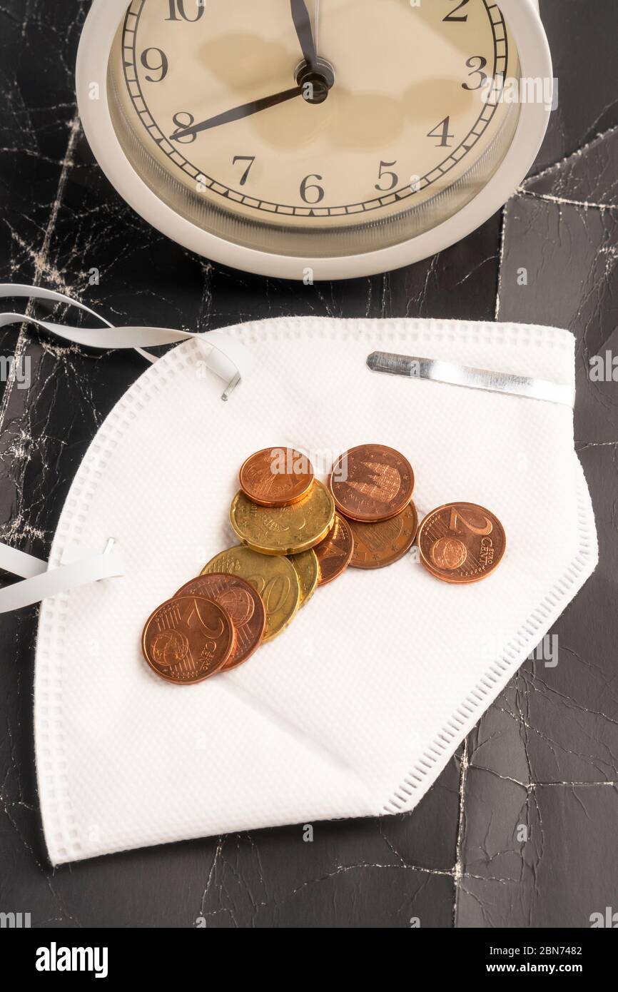 Kn95 medical respiratory mask with euro cents and alarm clock on ...