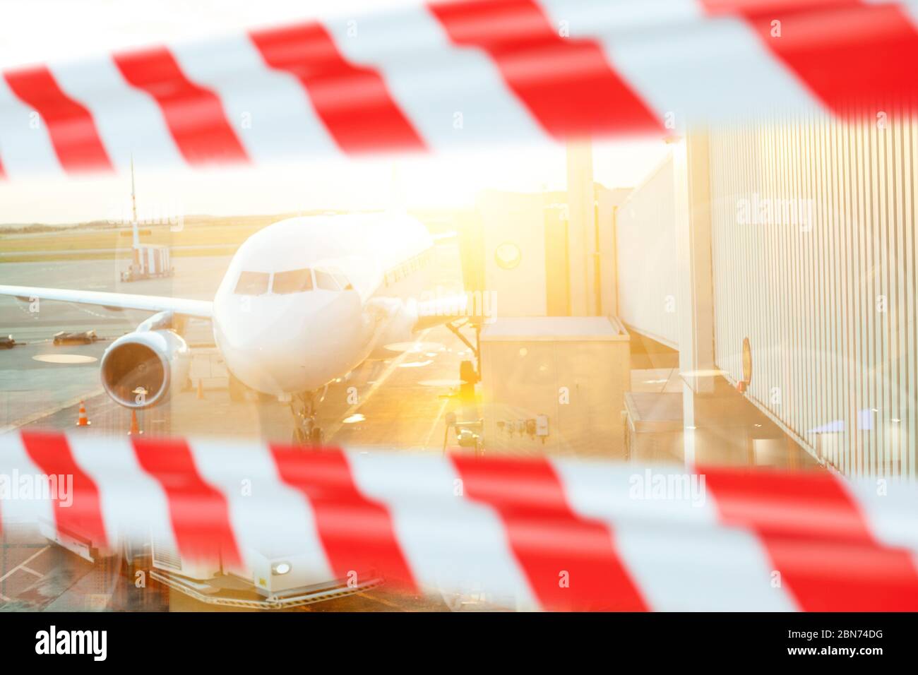 Closed aerport and plane in gate with warning tape Stock Photo - Alamy