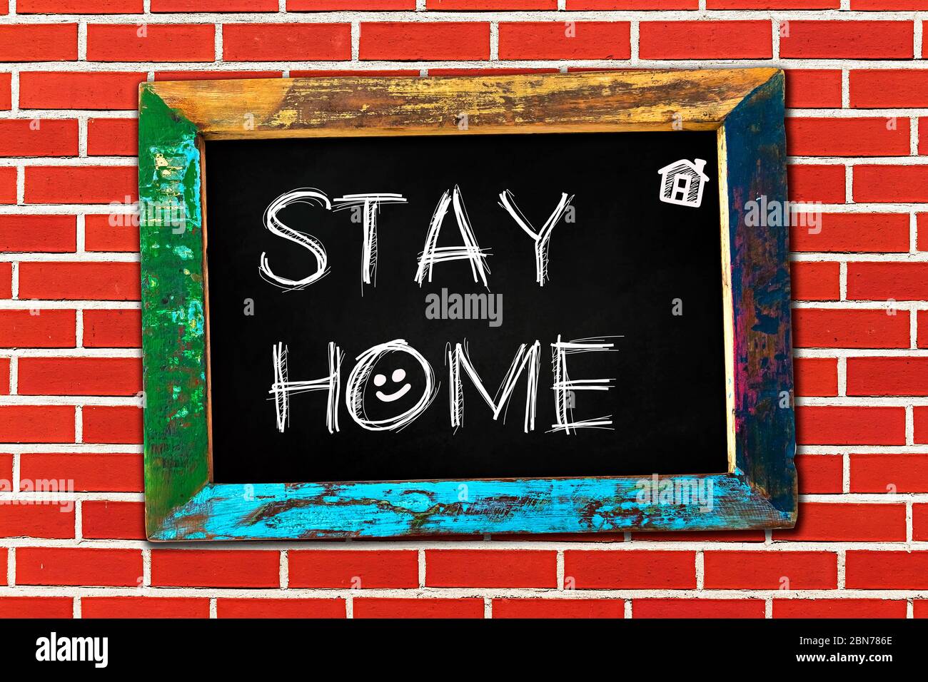Stay Home Handwritten on a Chalkboard Hanging on a Red Brick Wall Stock ...