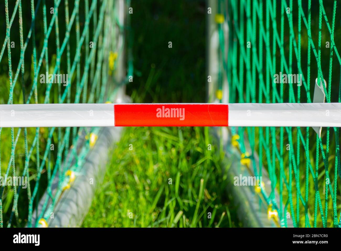 Red and white barrier tape in front of two soccer goals, concept of ...
