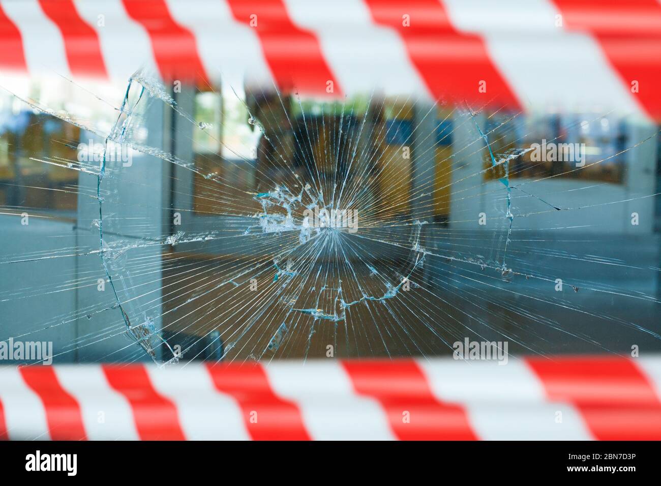 Broken showcase with warning tape. Smashed window Stock Photo - Alamy
