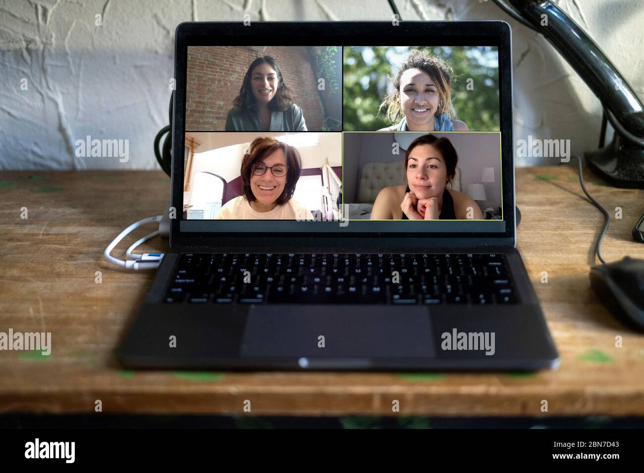 People having a virtual call online. Laptop on desk at home. Friends ...