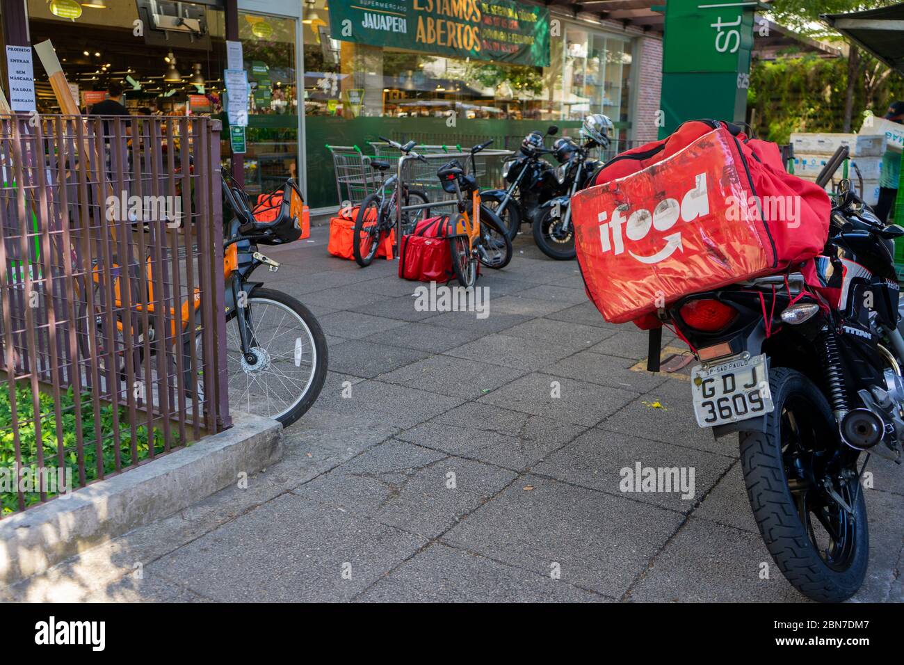 iFood delivery bags and bike itau bike in front of a grocery store in ...