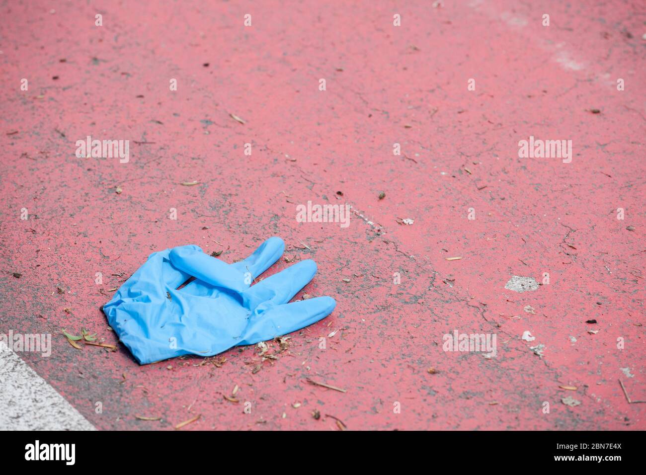 Used blue latex glove, disposable, thrown out on the ground in the ...