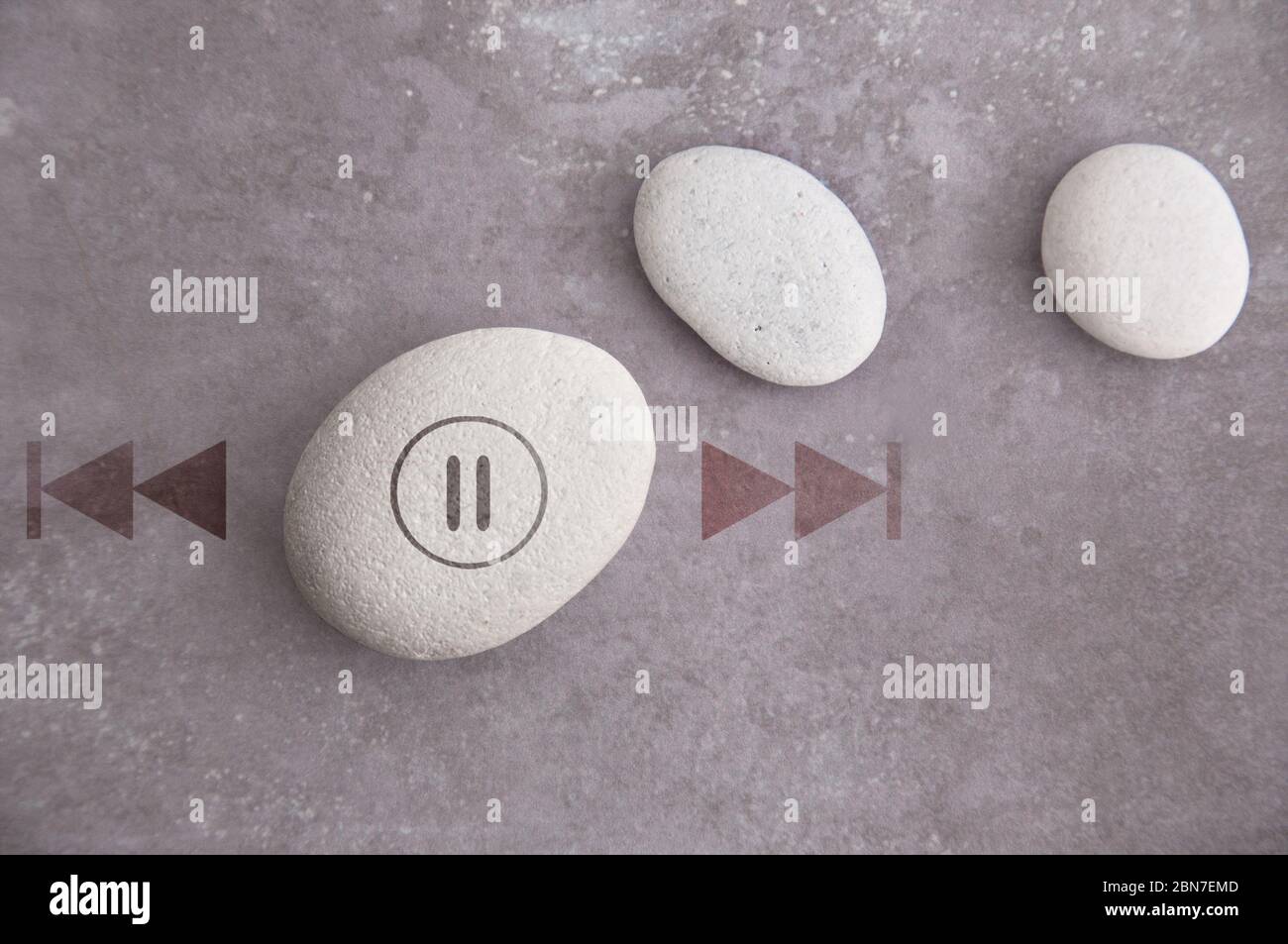 Zen stone with pause symbol, and fast forward, rewind on either side ...