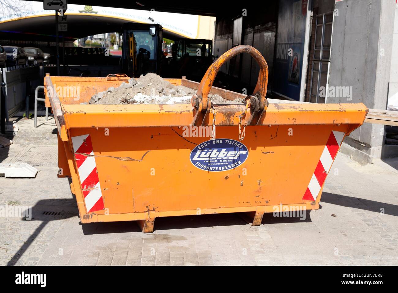 Orange skip for building rubble standing on a construction site ...