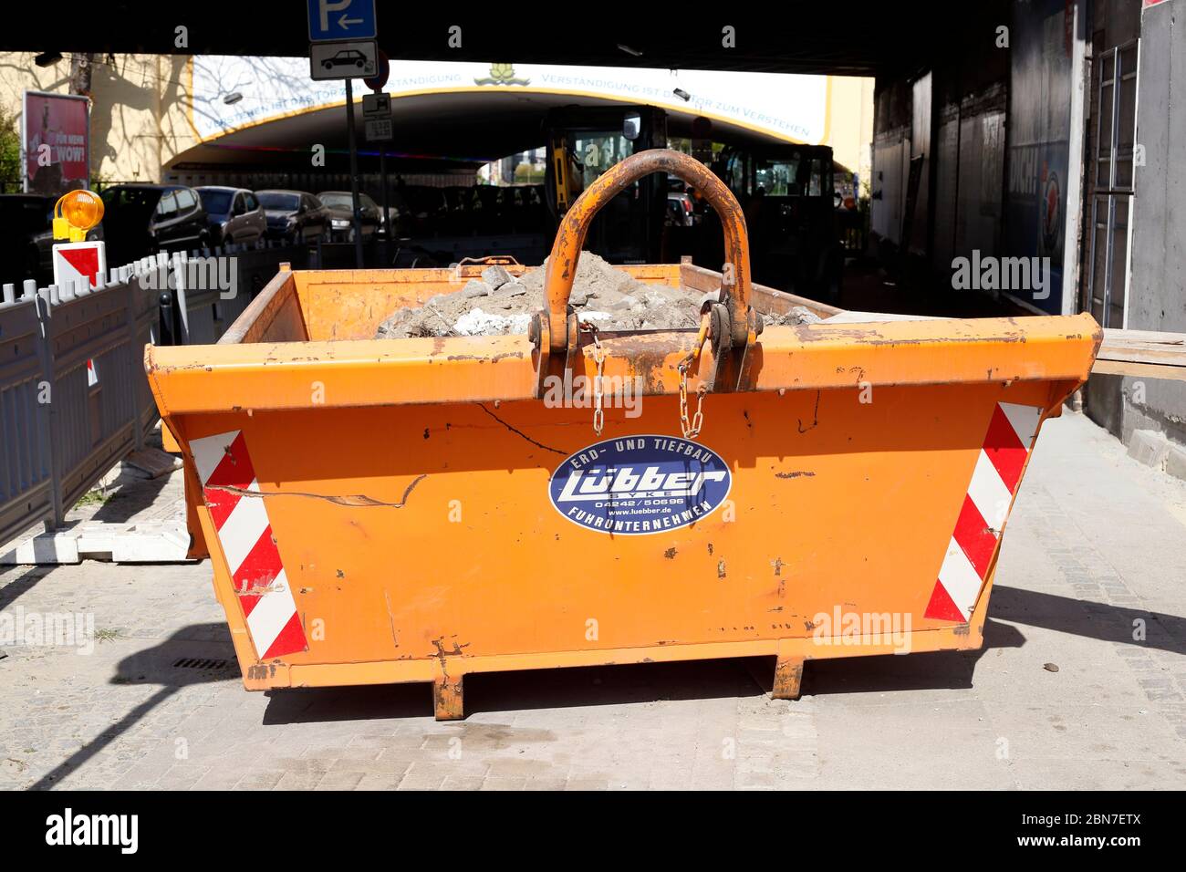 Orange skip for building rubble standing on a construction site ...