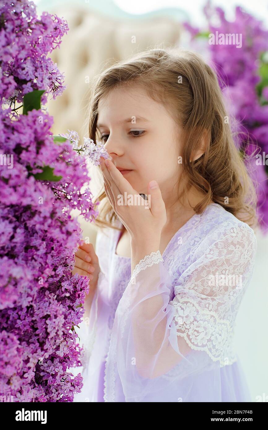 Beautiful little girl of preschool age in a delicate dress sitting on a ...
