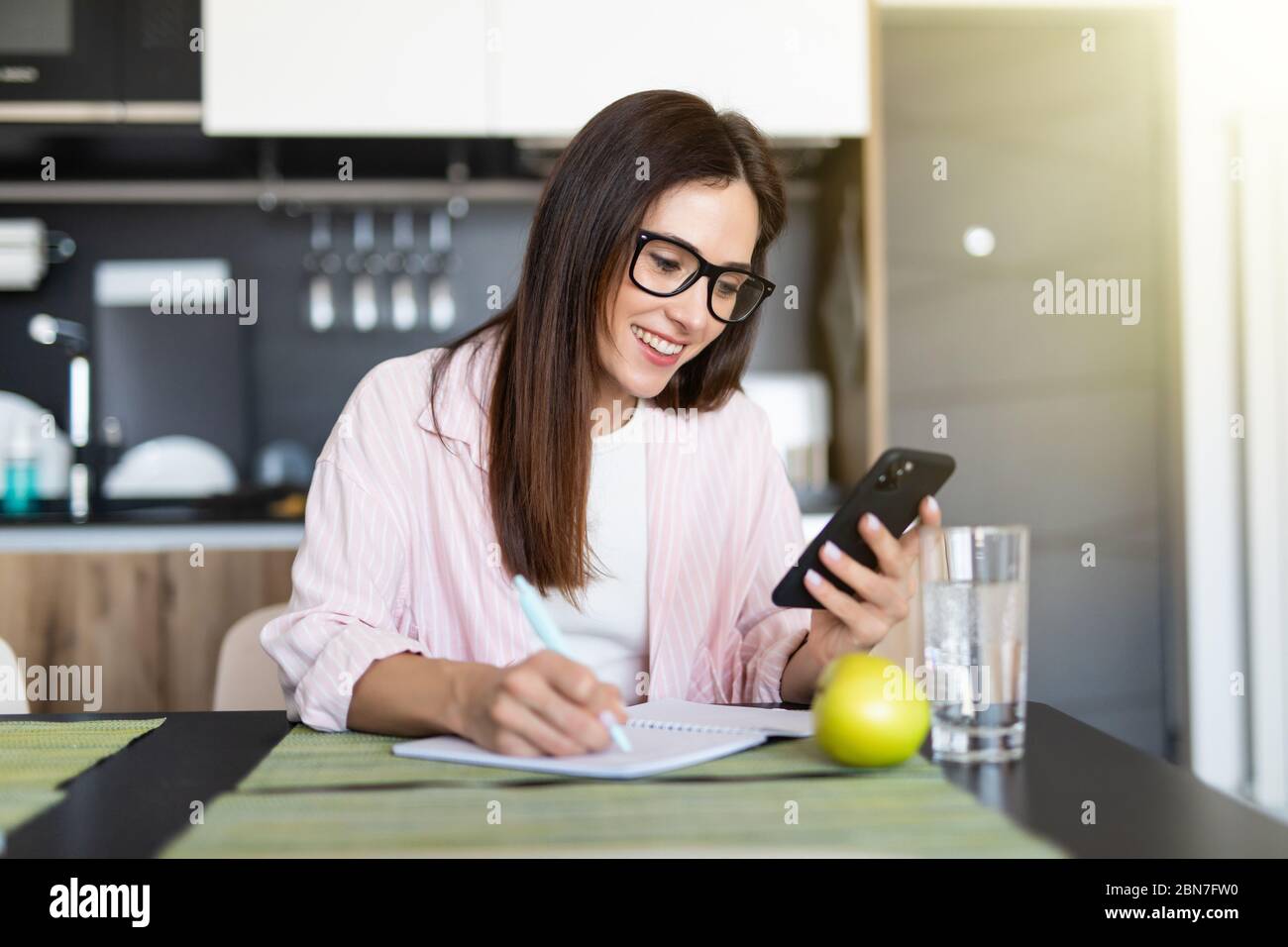 Young student doing her homework at home in the kitchen Stock Photo - Alamy
