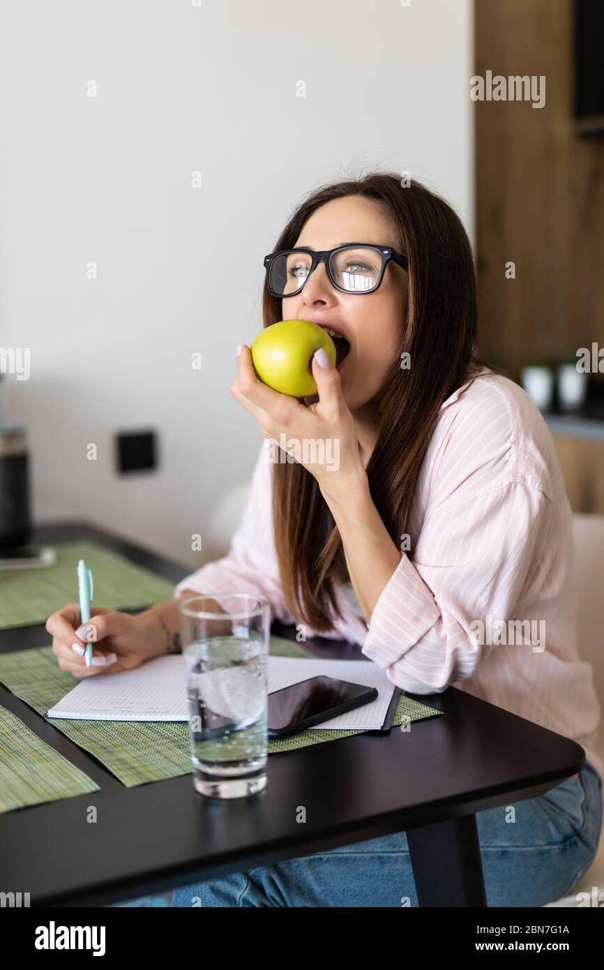 Healthy food concept. Young woman sitting at the table with fruits and ...