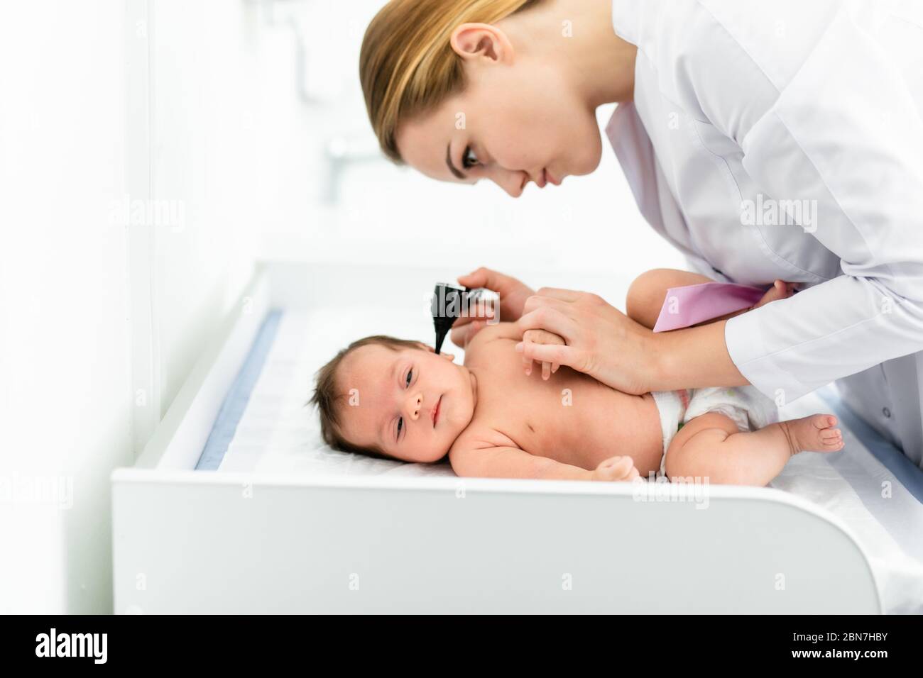 Pediatrician examines 2 week old baby's ear in new pediatric clinic ...