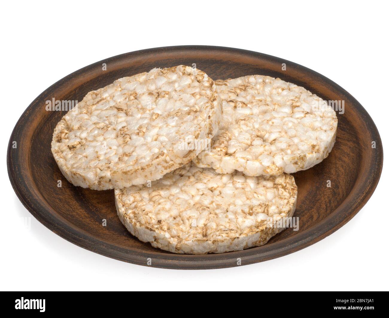 Puffed rice bread in a plate isolated on white background, diet crispy ...