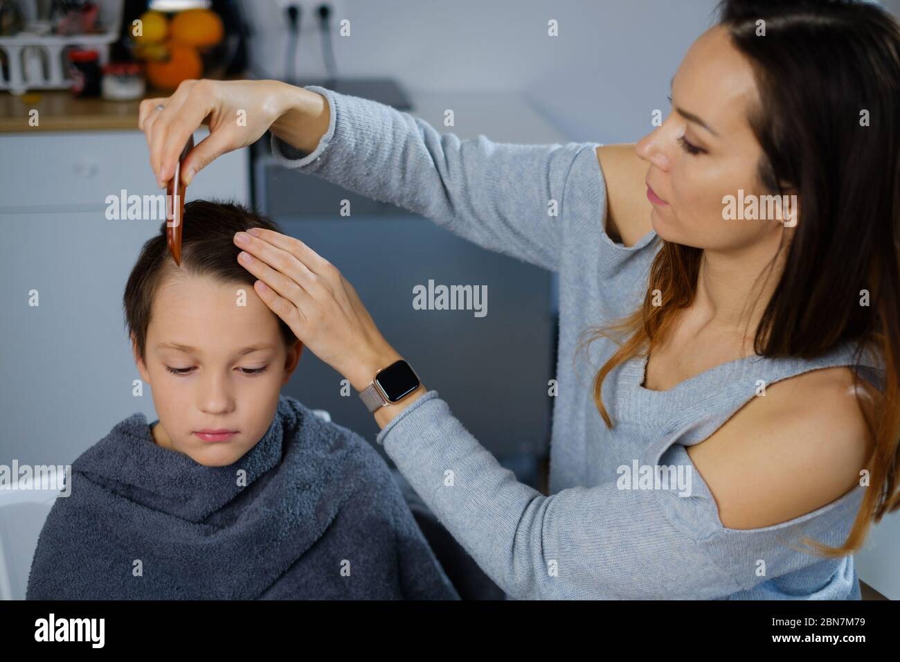 Mother making her son a haircut Stock Photo - Alamy